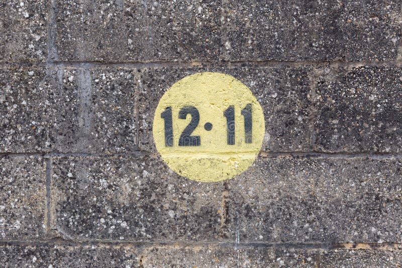 Black Numbers in a Yellow Circle Painted on Dark Brickwork Wall in the ...