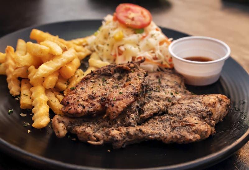 Black Pepper Marinated Chicken Fillet with Potato Sticks on a Black ...