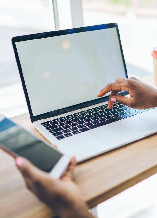 Black Person Typing on Keyboard and Browsing Smartphone in Hand Stock ...
