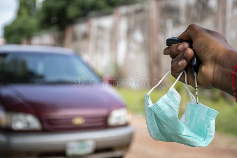 Black Person Using a Car Remote To Unlock a Car, Holding a Face Mask ...