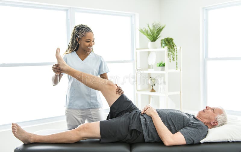 Black Physiotherapist Helping Senior Man With In Clinic Elderly Man