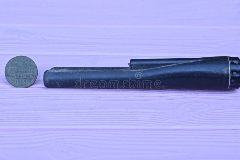 Black Pinpointer Lies on a Purple Table Next To Old Coin Stock Image ...