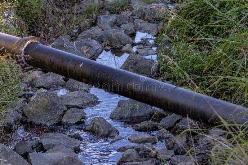 Black Pipe Crossing the Rocky Narrow Stream Stock Photo - Image of ...