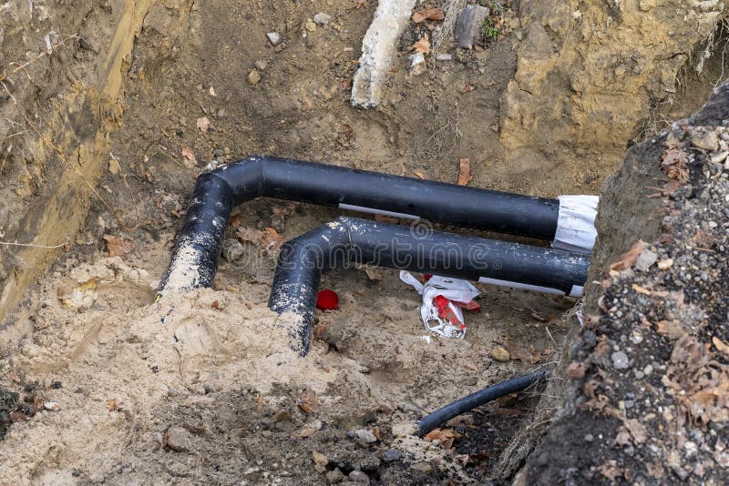 Black Pipes in the Ground and Sand. Installation of Sewer Pipes in the ...