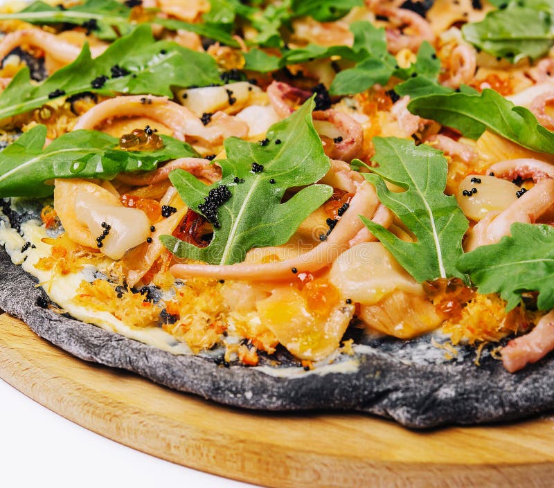 Black Pizza with Seafood on a Wooden Round Plate on a White Stock Image ...