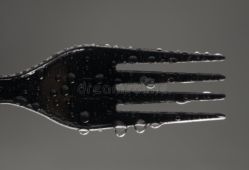 Black Plastic Fork and Spoon with Water Drops Showing Reflections and ...