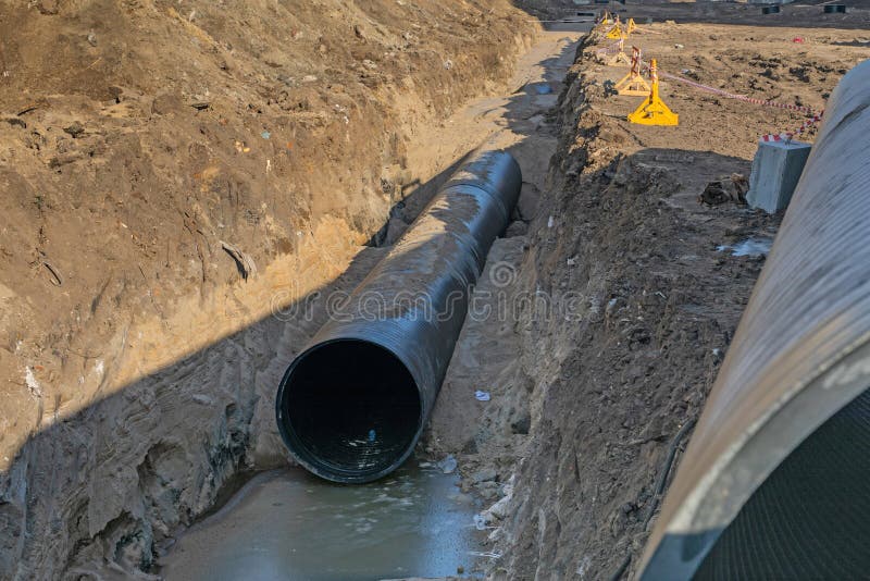 Black Plastic Pipes are in Trench of Ground. Process of Laying of ...