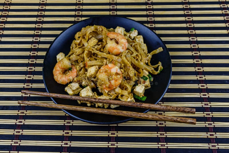 Black Plate with Pad Thai and Chopsticks on a Bamboo Mat. Top View ...