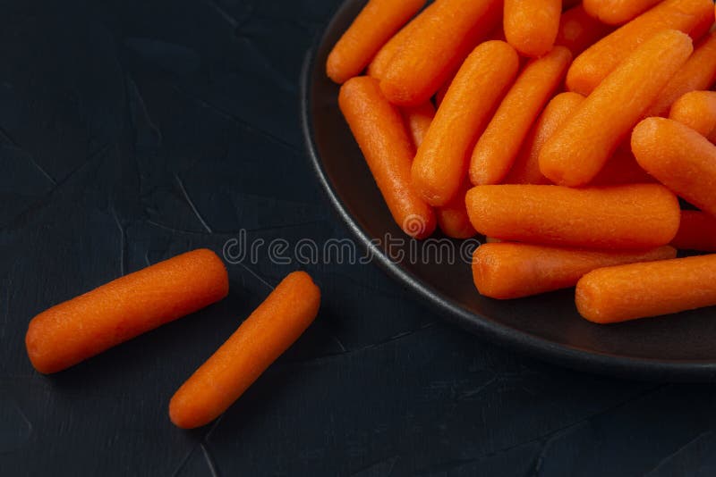 Black Plate with Small Peeled Pieces of Carrot on Dark Textured ...