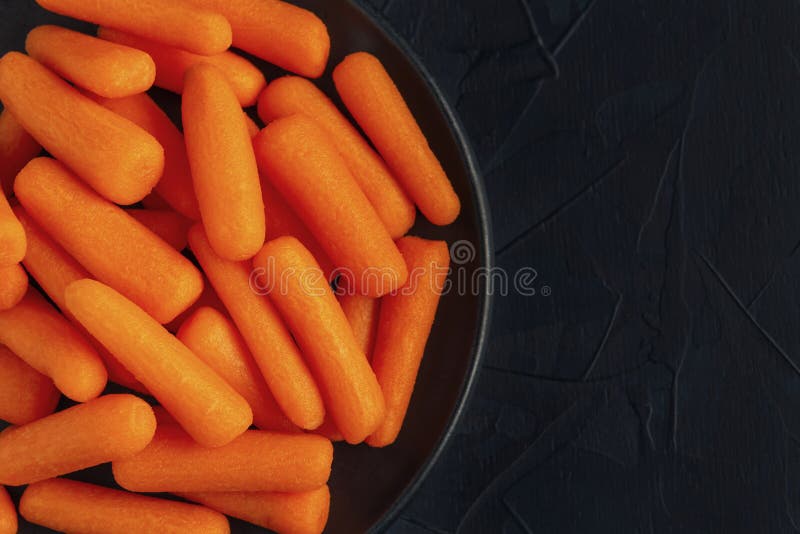 Black Plate with Small Peeled Pieces of Carrot on Dark Textured ...