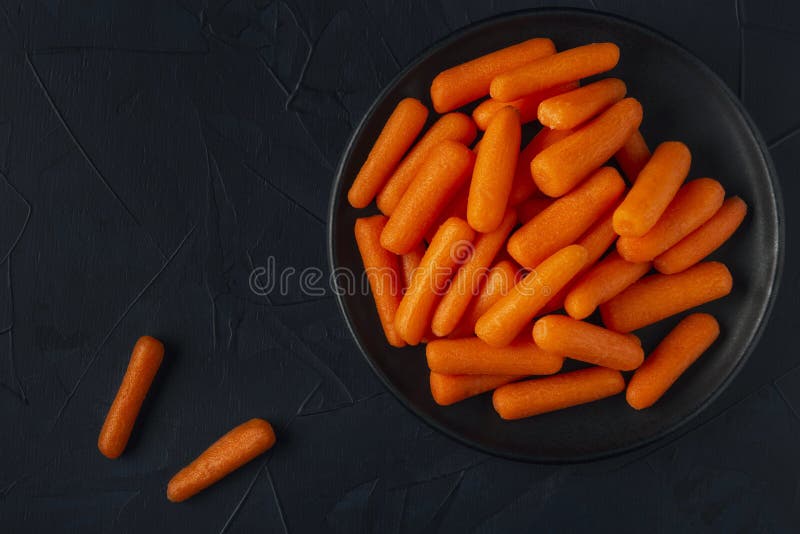 Black Plate with Small Peeled Pieces of Carrot on Dark Textured ...
