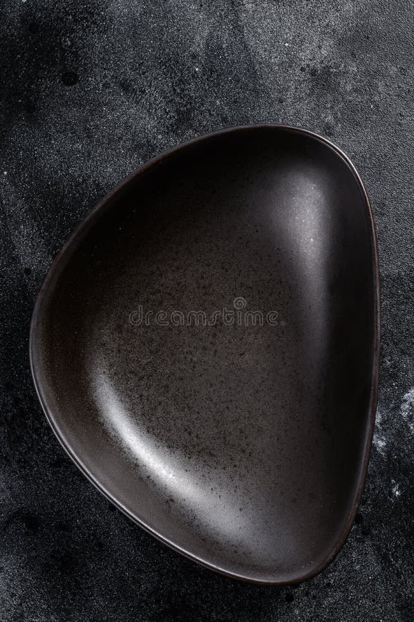 Black Plate Triangular Shape on Textured Black Background. Top View ...