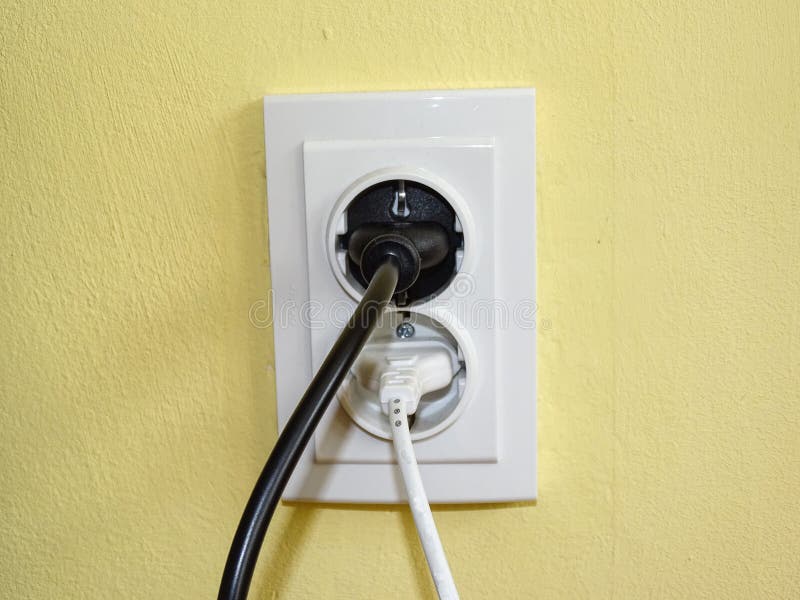 A Black Plug and a White Plug in the Socket Stock Photo - Image of ...