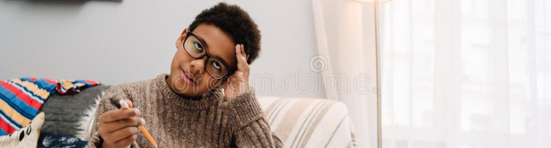 Black Puzzled Boy Doing Homework while Sitting on Sofa Stock Photo ...