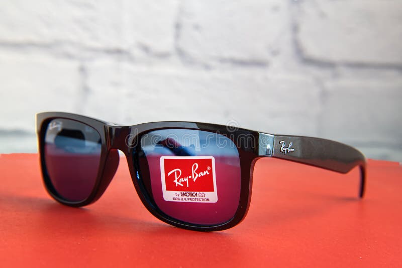 Black Ray-Ban Sunglasses with the Brand Logo in Plastic Frames on a Red ...