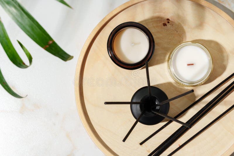 Black Reed Diffuser, Amber Candle, and Wooden Tray on White Surface ...