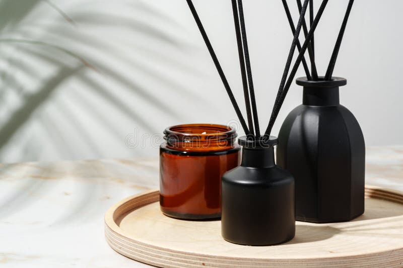 Black Reed Diffuser, Amber Candle, and Wooden Tray on White Surface ...