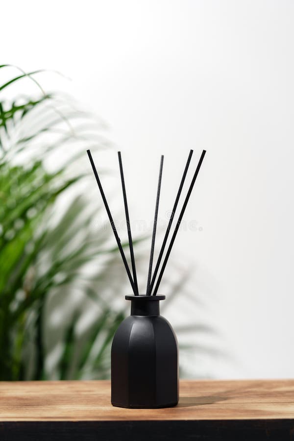 Black Reed Diffuser Bottle on Wooden Tabletop with Green Plant Stock ...