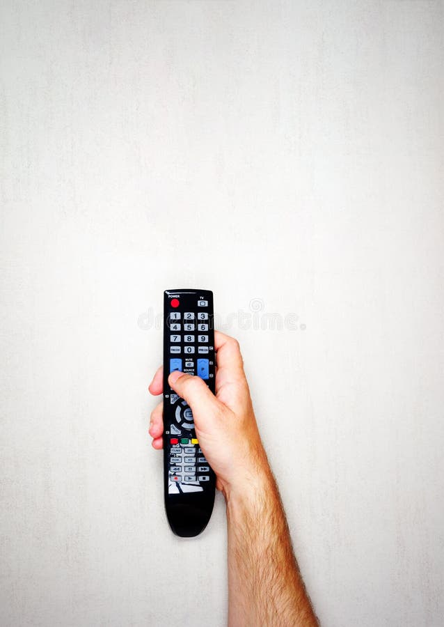 Black Remote Control from the TV in a Male Hand on a Light Gray ...