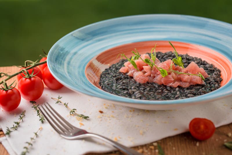 Black Risotto with Slices of Salmon Garnished with Microgreen Stock ...