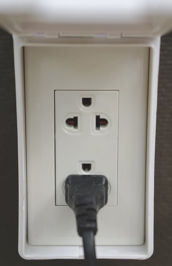 A Black Rubber Plug Inserted in Plastic Power Outlet Three Hole Stock ...
