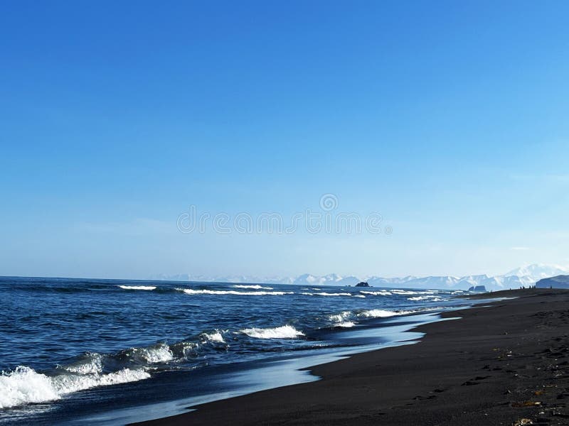Black Sand Beach with Ocean Waves Under Clear Blue Sky and Distant ...