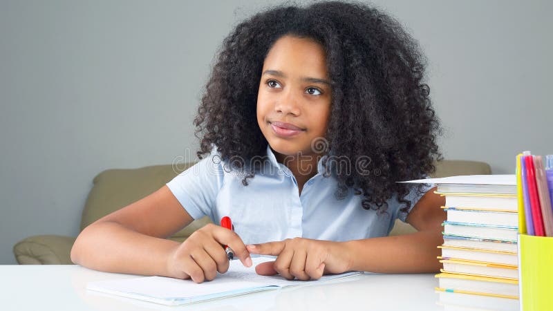 Black School Girl Writes in a Notebook, Doing Homework Stock Photo ...