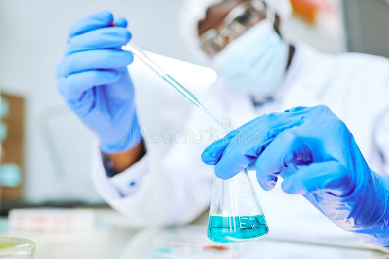Black Scientist Taking Liquid Samples with Pipette in Laboratory Stock ...
