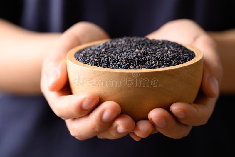 Black Sesame Seed in Bowl Holding by Hand Stock Image - Image of ...