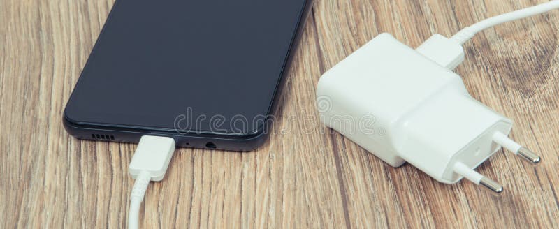 Black Smartphone and Charger Using To Charge Empty Battery. Various ...