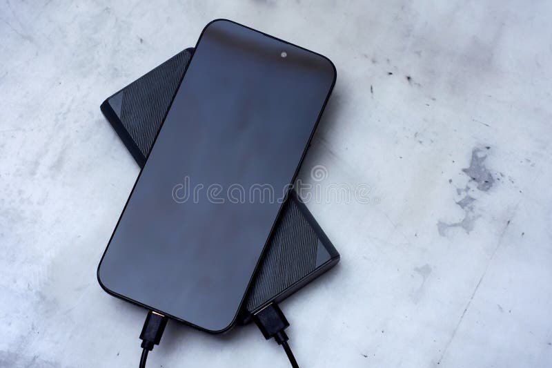 Black Smartphone is Charging from a Portable Power Bank on a Textured ...