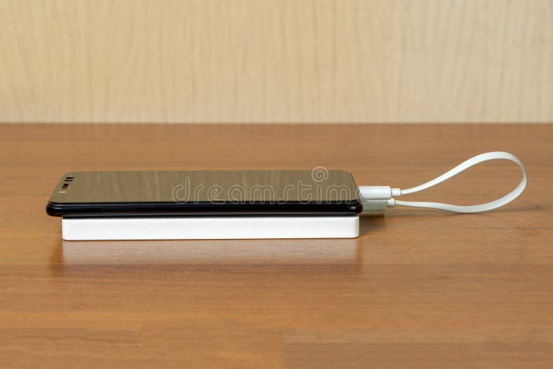 Black Smartphone Charging with White Power Bank through USB Cable, Side ...