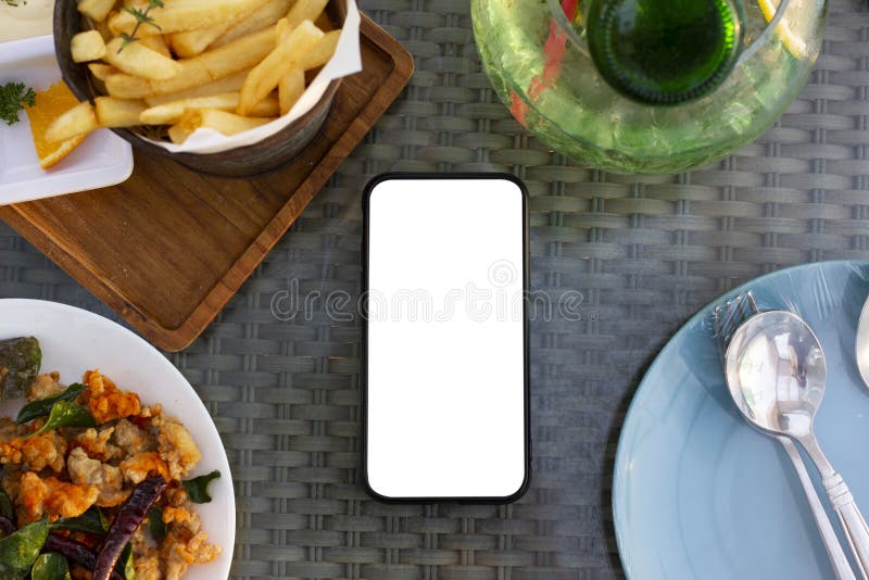 Black Smartphone with White Screen Mockup on Dining Table in Cafe or ...