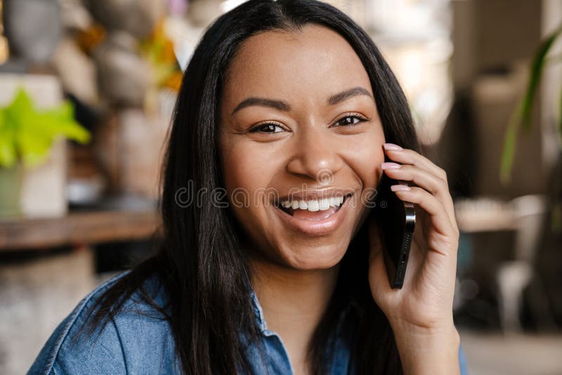 Black Smiling Woman Talking on Cellphone Sitting in Cafe Stock Image ...