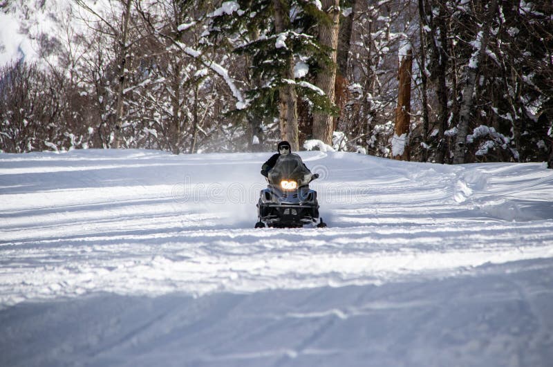 Black Snowmobile Rides on a Snowy Road in the Caucasus Mountains Stock ...