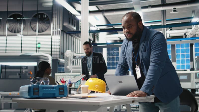 Black Solar Panel Engineer in a High Tech Facility Doing an Inspection ...