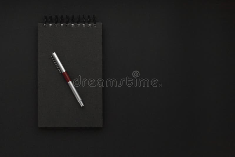 Black Spiral Notebook with a Silver Fancy Pen on Top of it in the ...