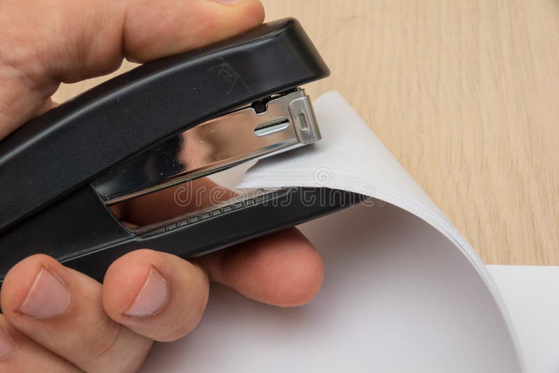 A Black Stapler in His Hand Pierces Many Sheets of Paper Stock Photo ...