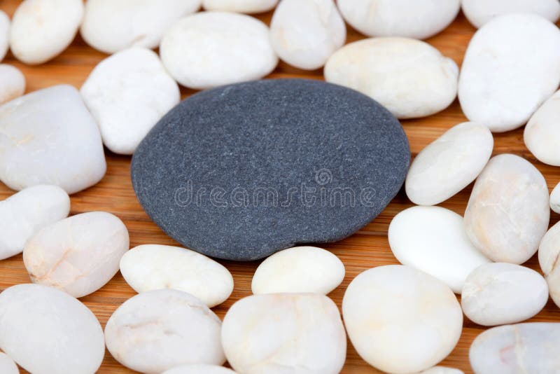 A Black Stone and Many Small White Stones Stock Image - Image of ...