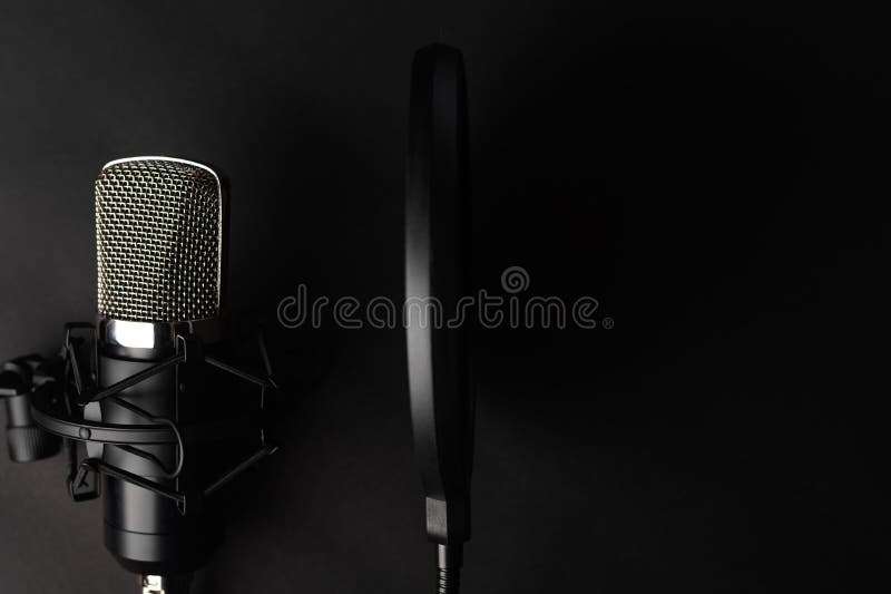 Black Studio Microphone on a Black Background with a Pop Filter with ...