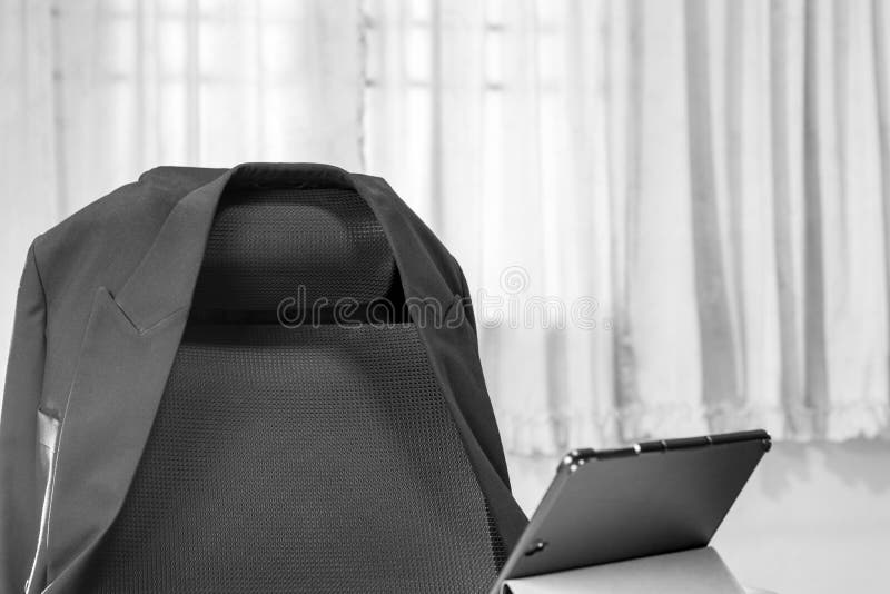 Black Suit Hang on Chair Behind White Table and Tablet Stock Photo ...