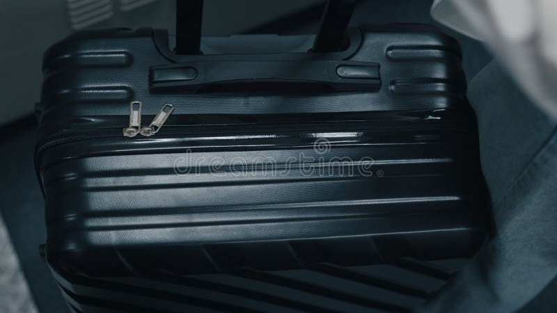 Black Suitcase with Zipper and Adjustable Handle on Floor in Train ...