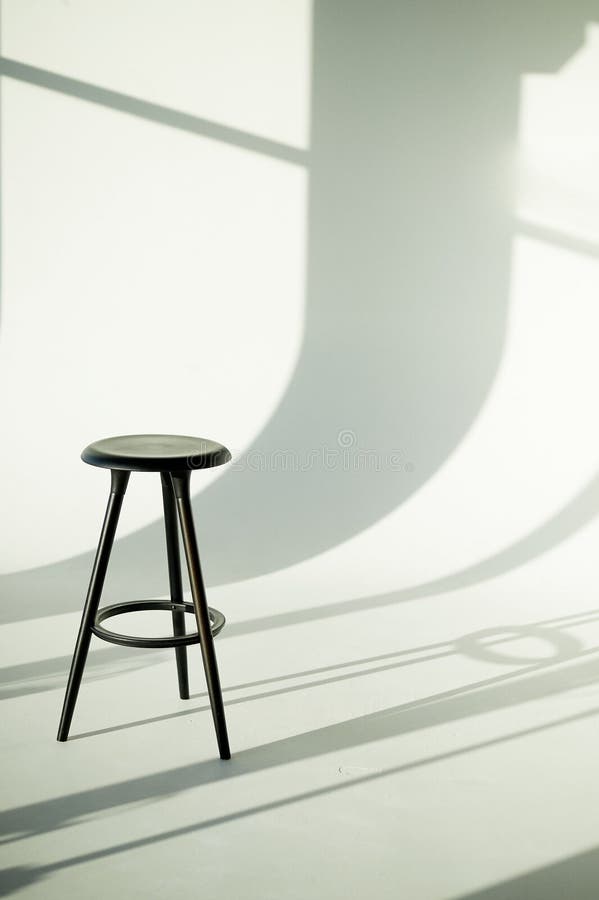 A Black Tall Stool on Three Legs in a White Studio Bathed in Light ...