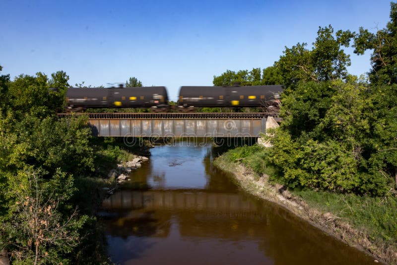 Black Tank Cars and Reflections Crossing a Bridge Stock Photo - Image ...