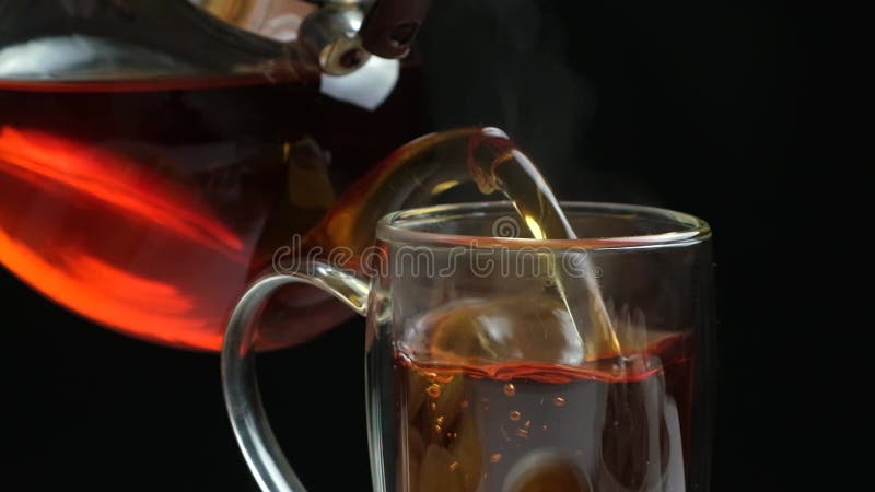 Black Tea from the Kettle is Poured into a Glass Cup with a Double ...