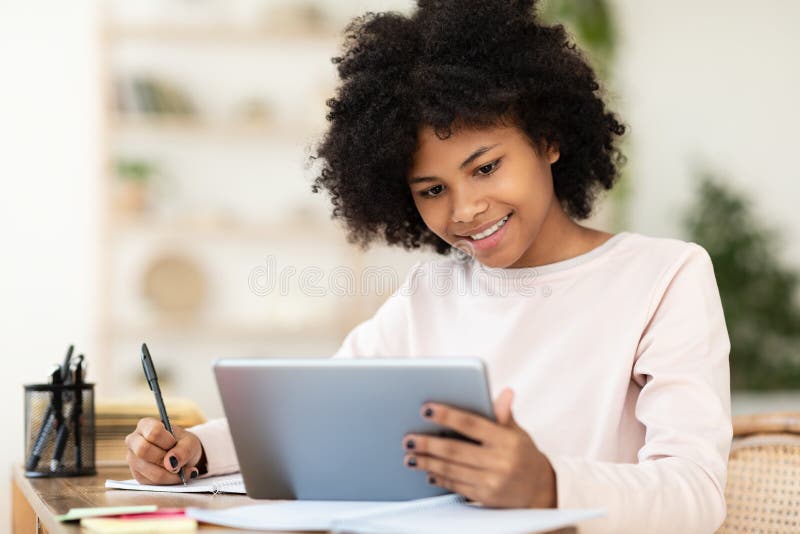 Black Teenager Girl Using Tablet Computer Learning Distantly at Home ...