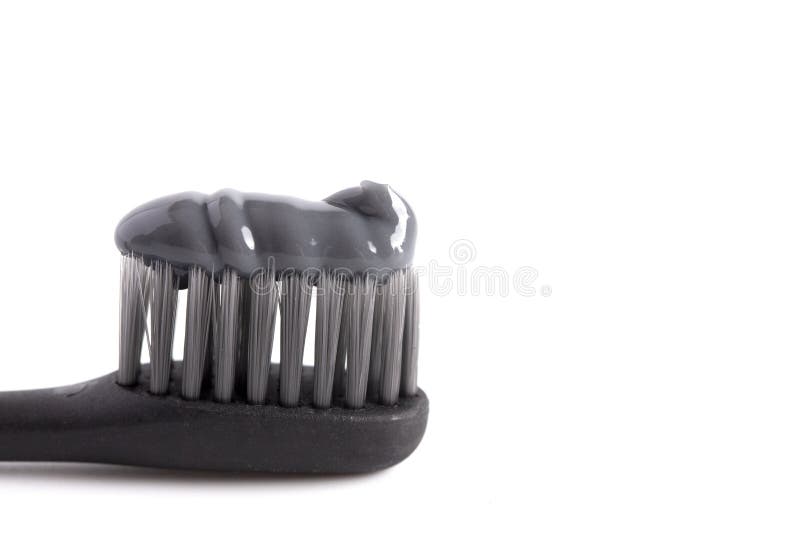 A Black Toothbrush with Black Activated Charcoal Toothpaste on a White ...