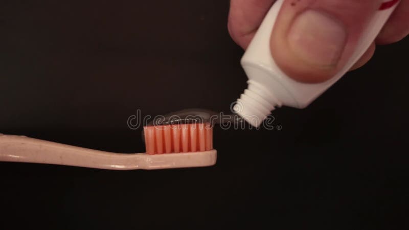 Black Toothpaste Squeezed Onto a Toothbrush. Slow Motion of Toothpaste ...