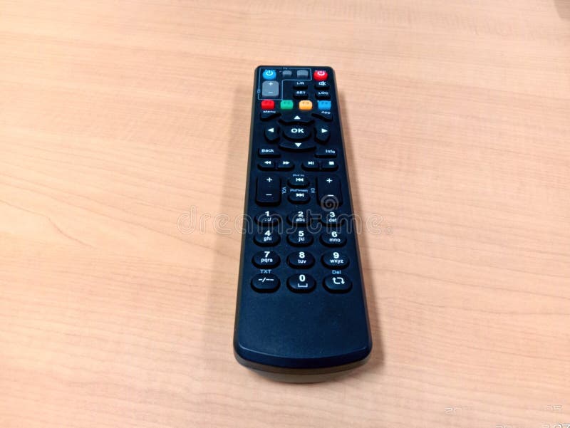 A Black TV Remote on a Brown Table Stock Image - Image of office ...
