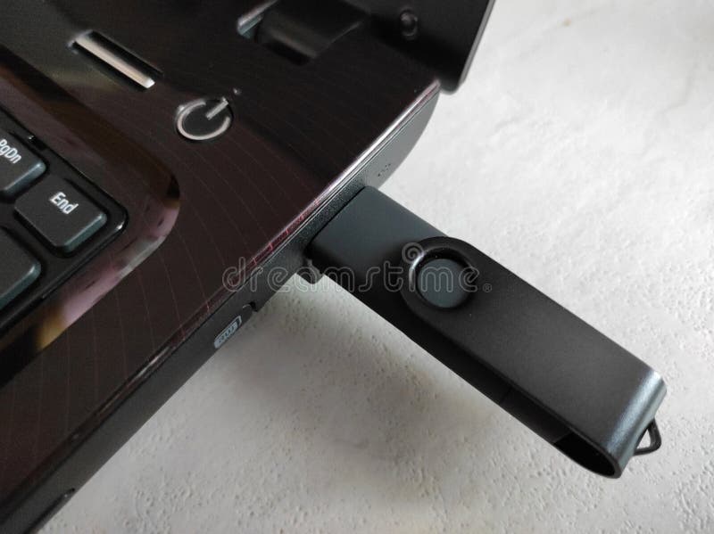 A Black USB Flash Drive is Plugged into the Side of a Laptop. the ...